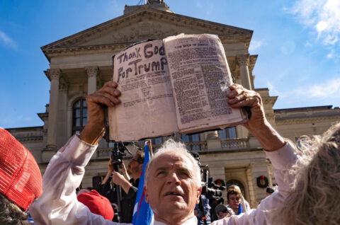 A preacher holds up his Bible while supporters of Donald Trump host a ...